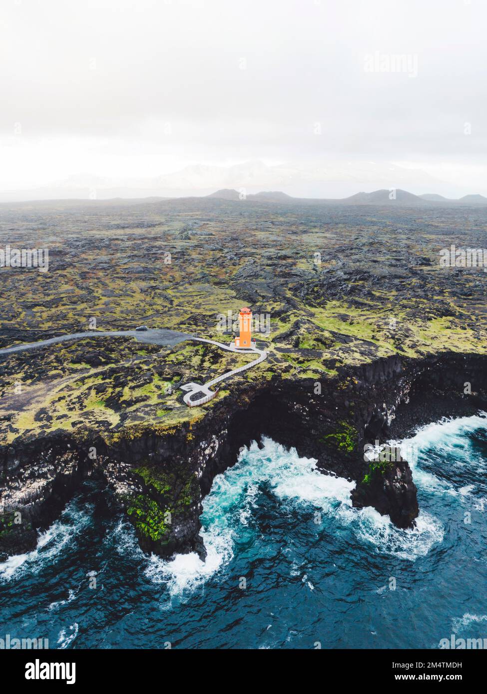 Vertical photo of Svortuloft Lighthouse on the volcanic coast of ...