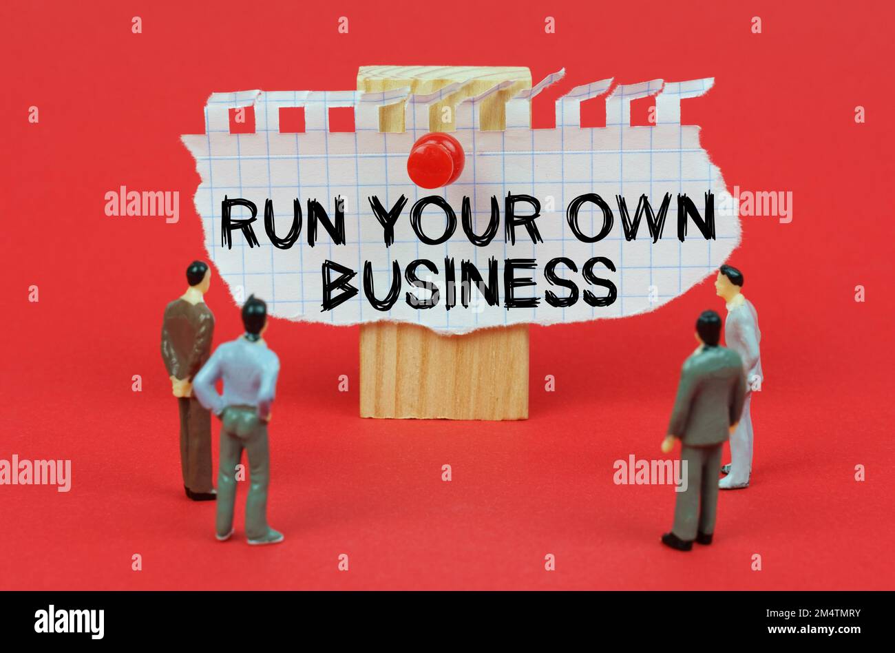 Business Concept On A Red Background Are Miniature Figures Of People Looking At An Ad With The