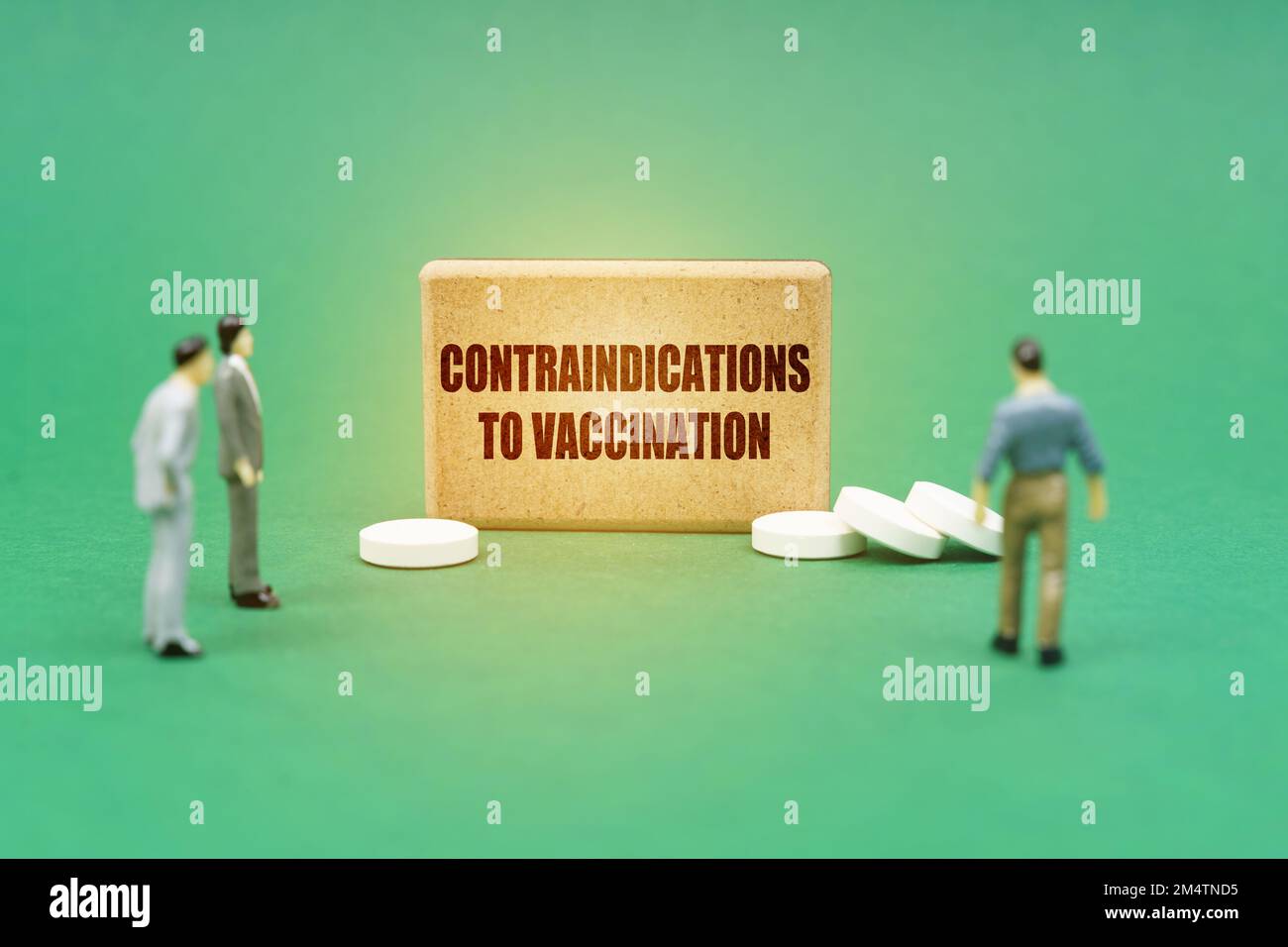 Medical concept. On the green surface are pills, miniature figures of ...