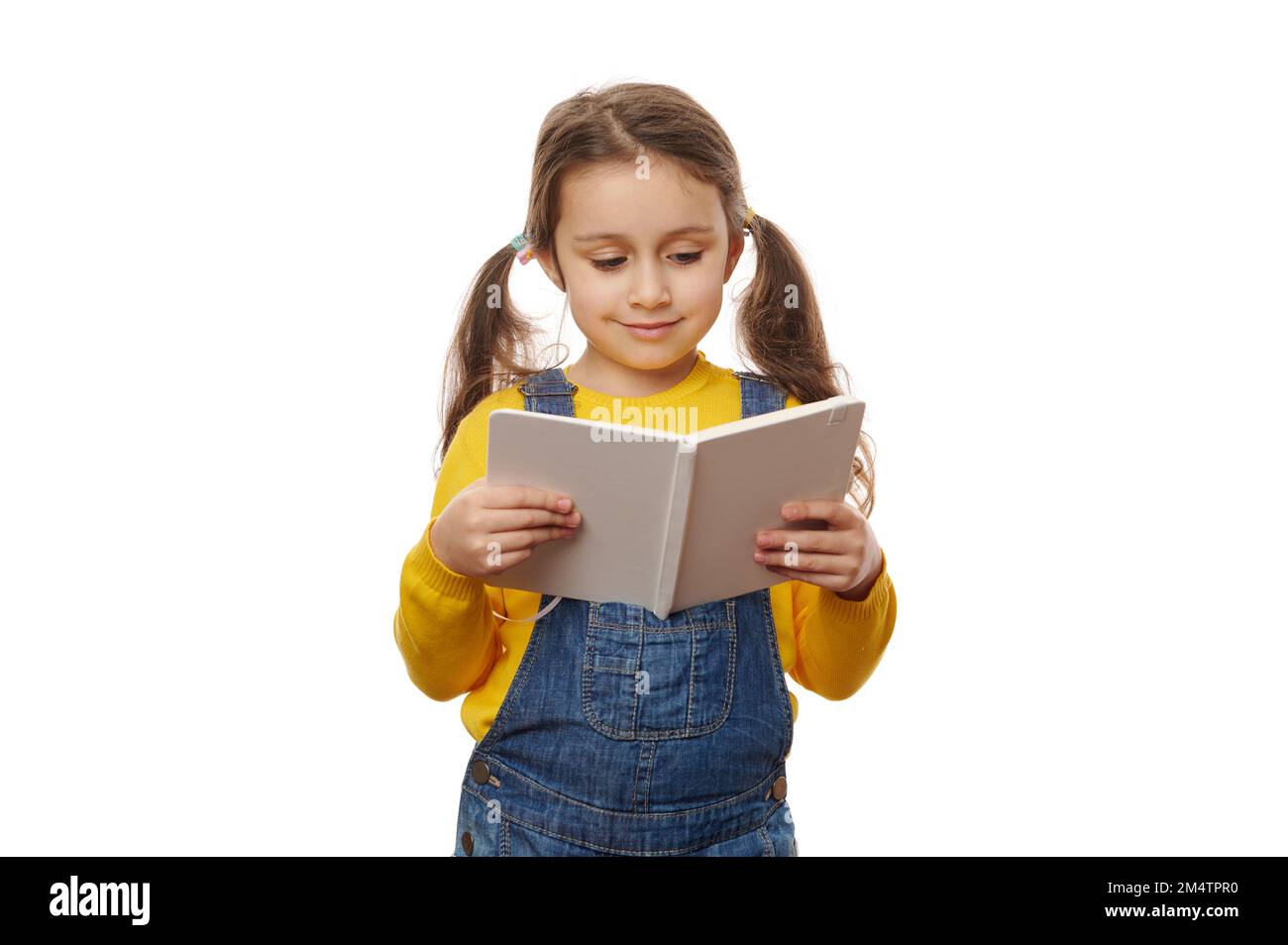 Adorable Caucasian little girl with ponytails, wearing yellow pull and ...