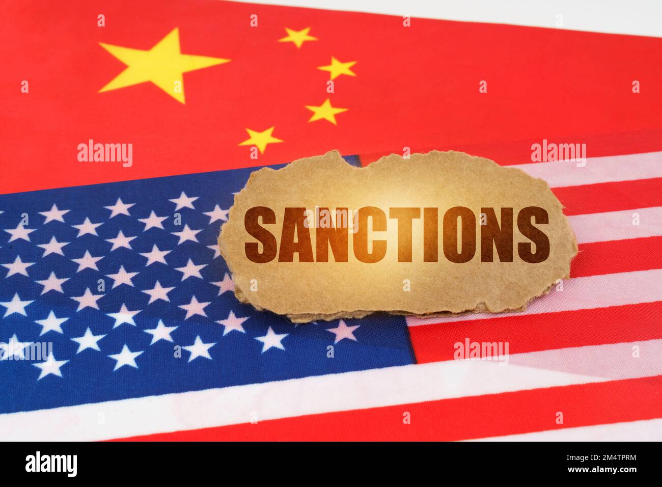 Political concept. On the flags of the USA and China lies a cardboard ...