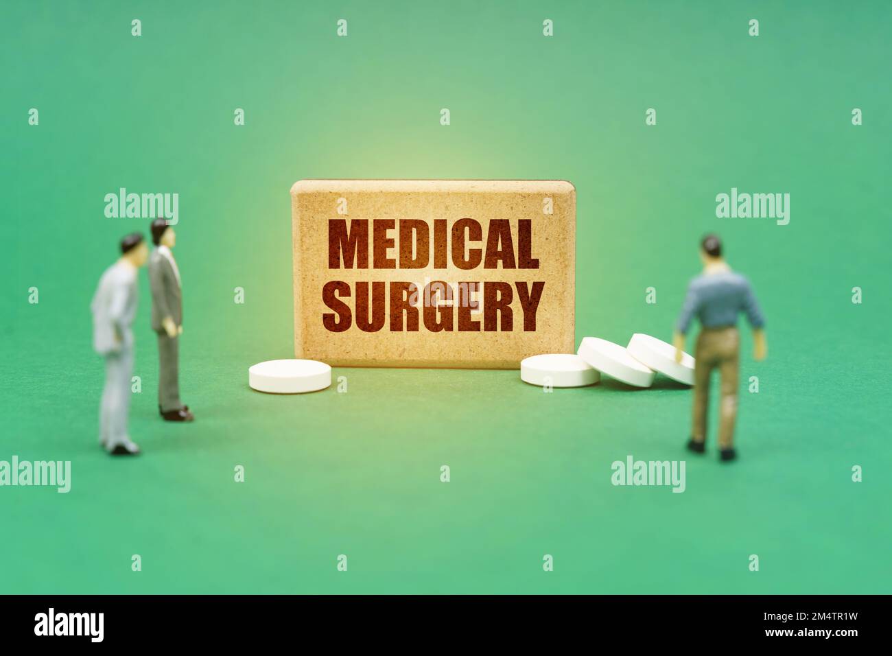 Medical concept. On the green surface are pills, miniature figures of ...
