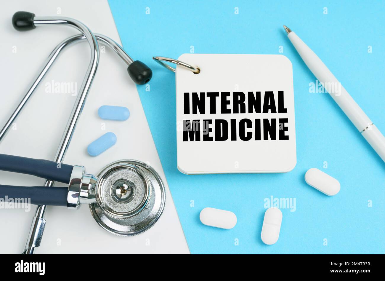 Medical concept. On a white and blue surface are pills, a stethoscope ...