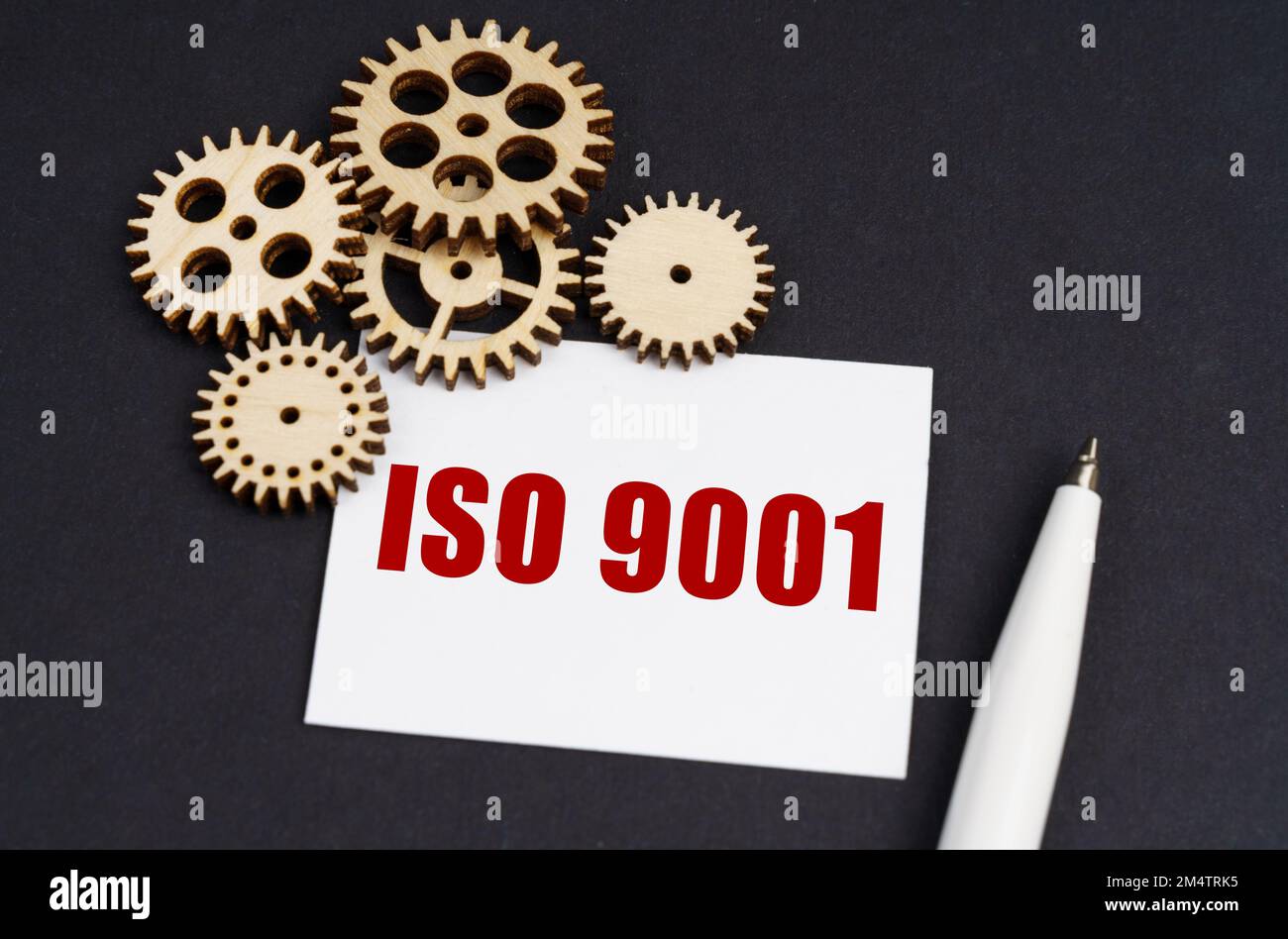 Industrial concept. On the black surface are gears, a pen and a ...