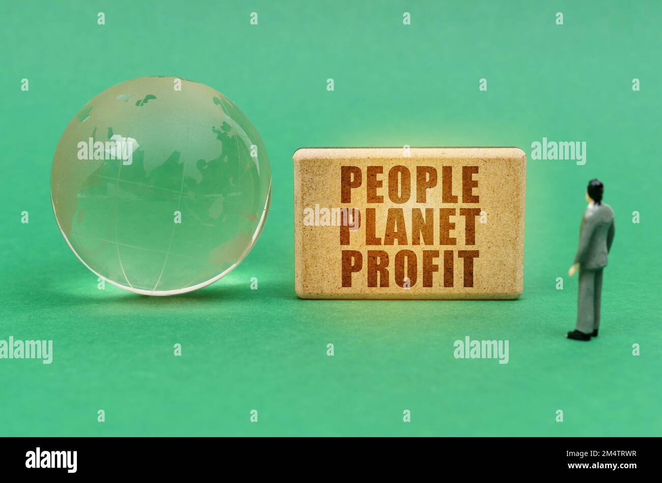Ecological concept. On the green surface is a globe and a figurine of a ...
