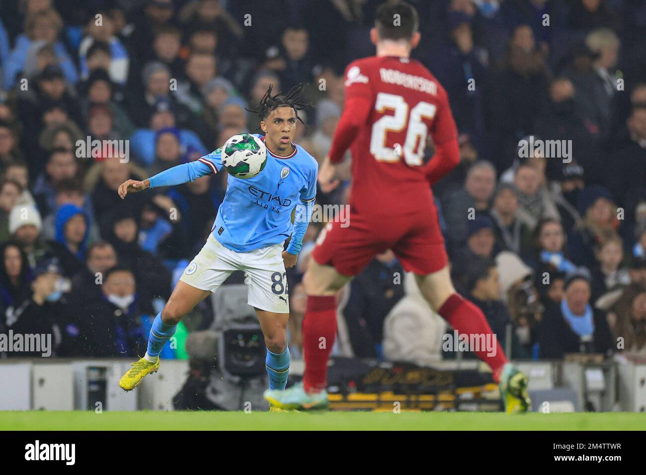 Rico Lewis #82 of Manchester City controls the ball watched by Andrew ...