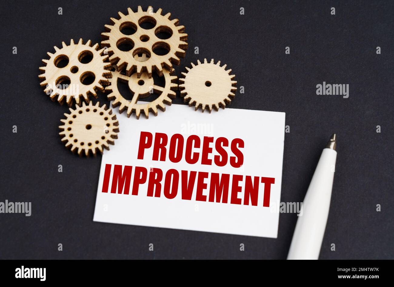 Industrial concept. On the black surface are gears, a pen and a ...