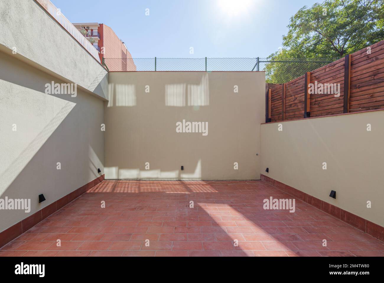 Enclosed space fenced with high walls on all sides. Backyard of house ...