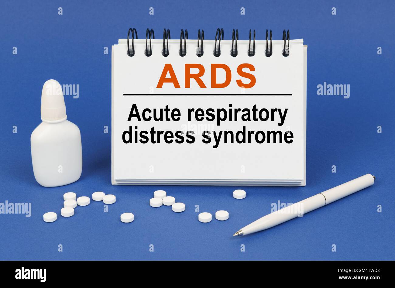 Medical concept. On a blue background, a pen, tablets and a notepad ...