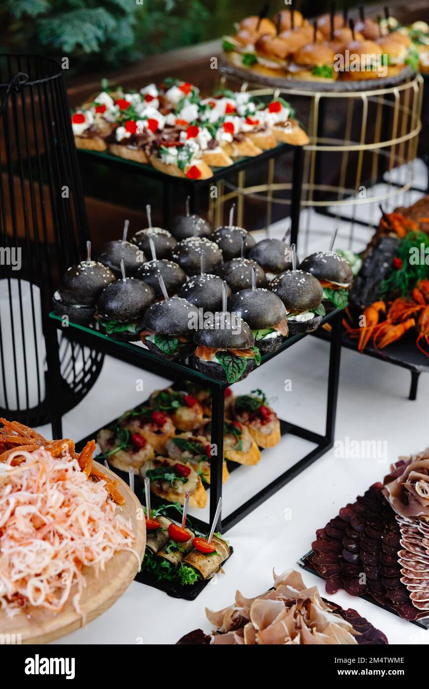 Mini burgers snacks on a wooden table, beautifully decorated catering ...