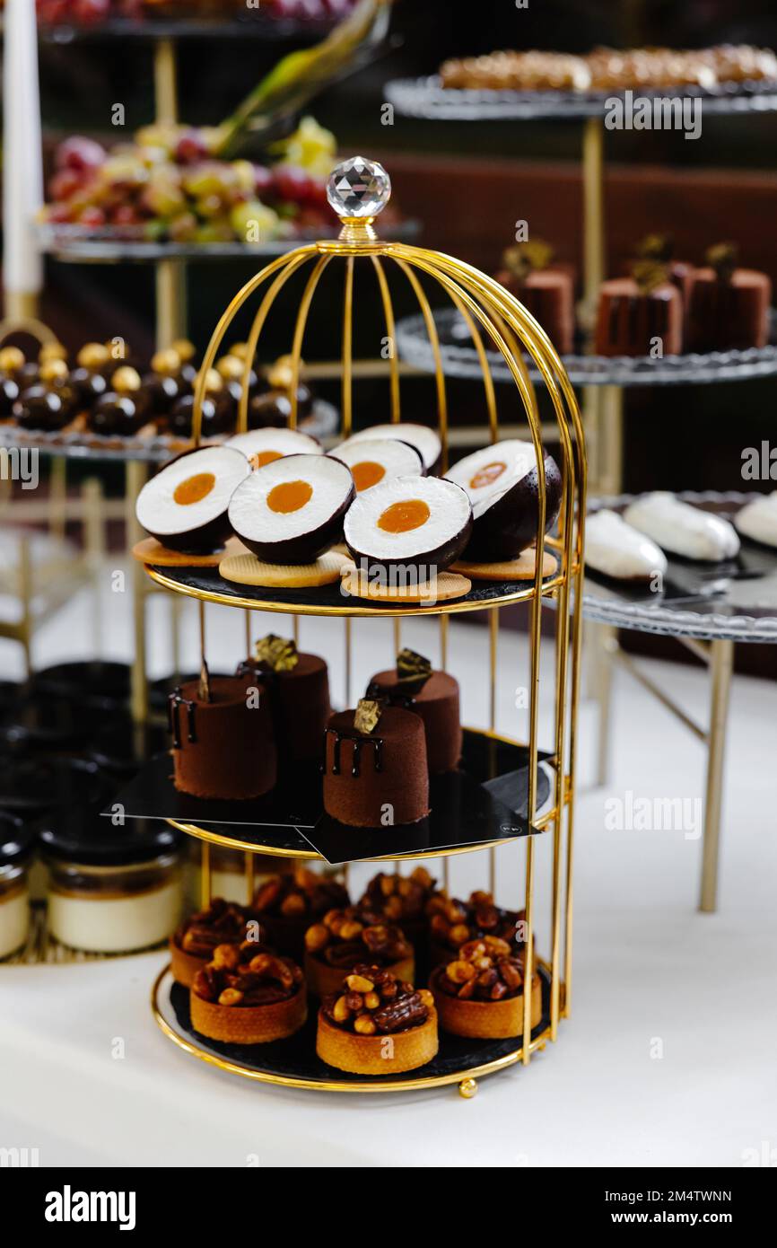 Many cakes standing among the candy bar. Sweet table. Banquet table ...