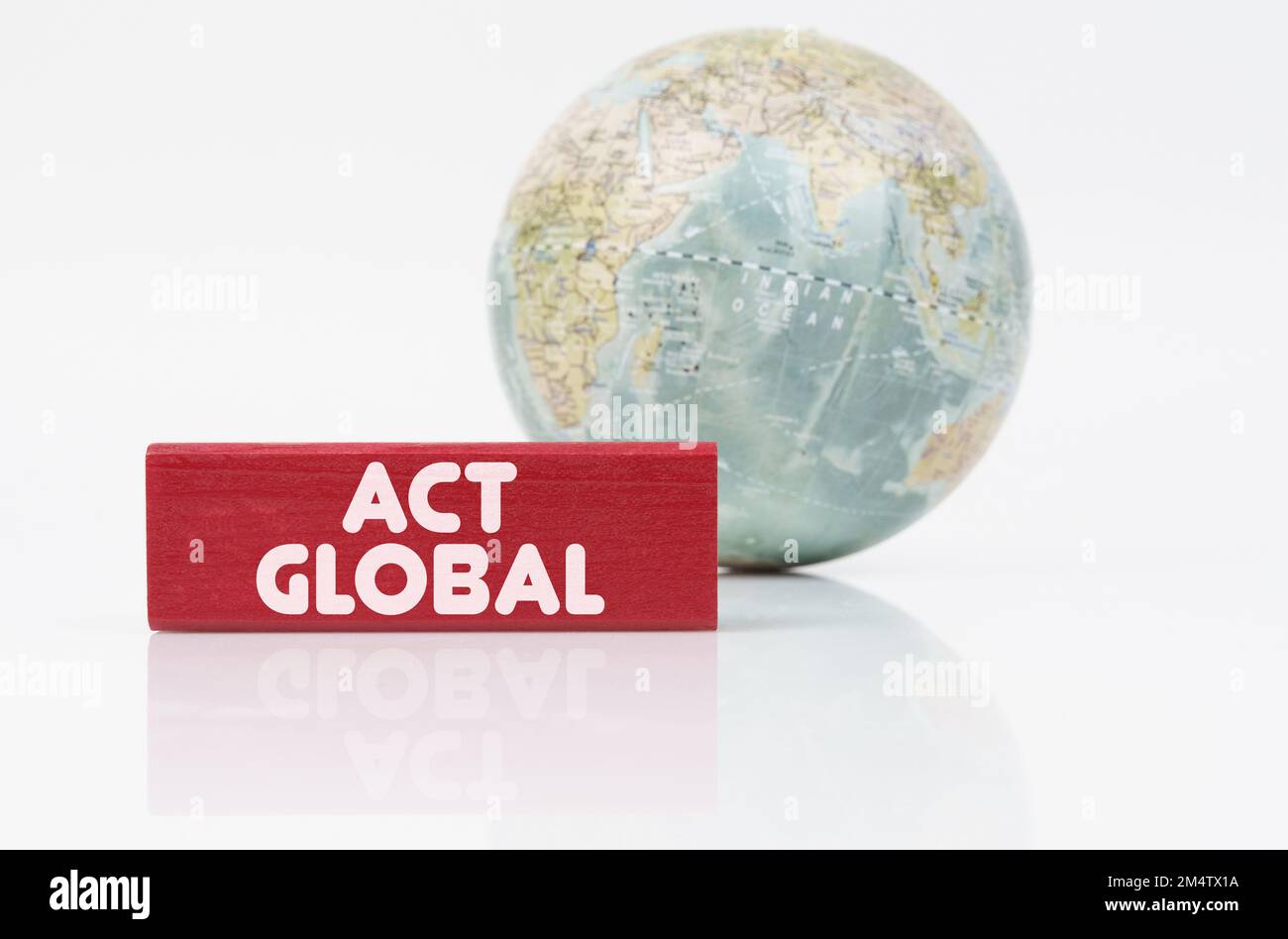 Business and technology concept. Near the globe is a red plaque with the inscription - act ...