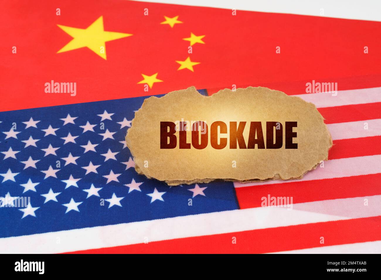 Political concept. On the flags of the USA and China lies a cardboard ...