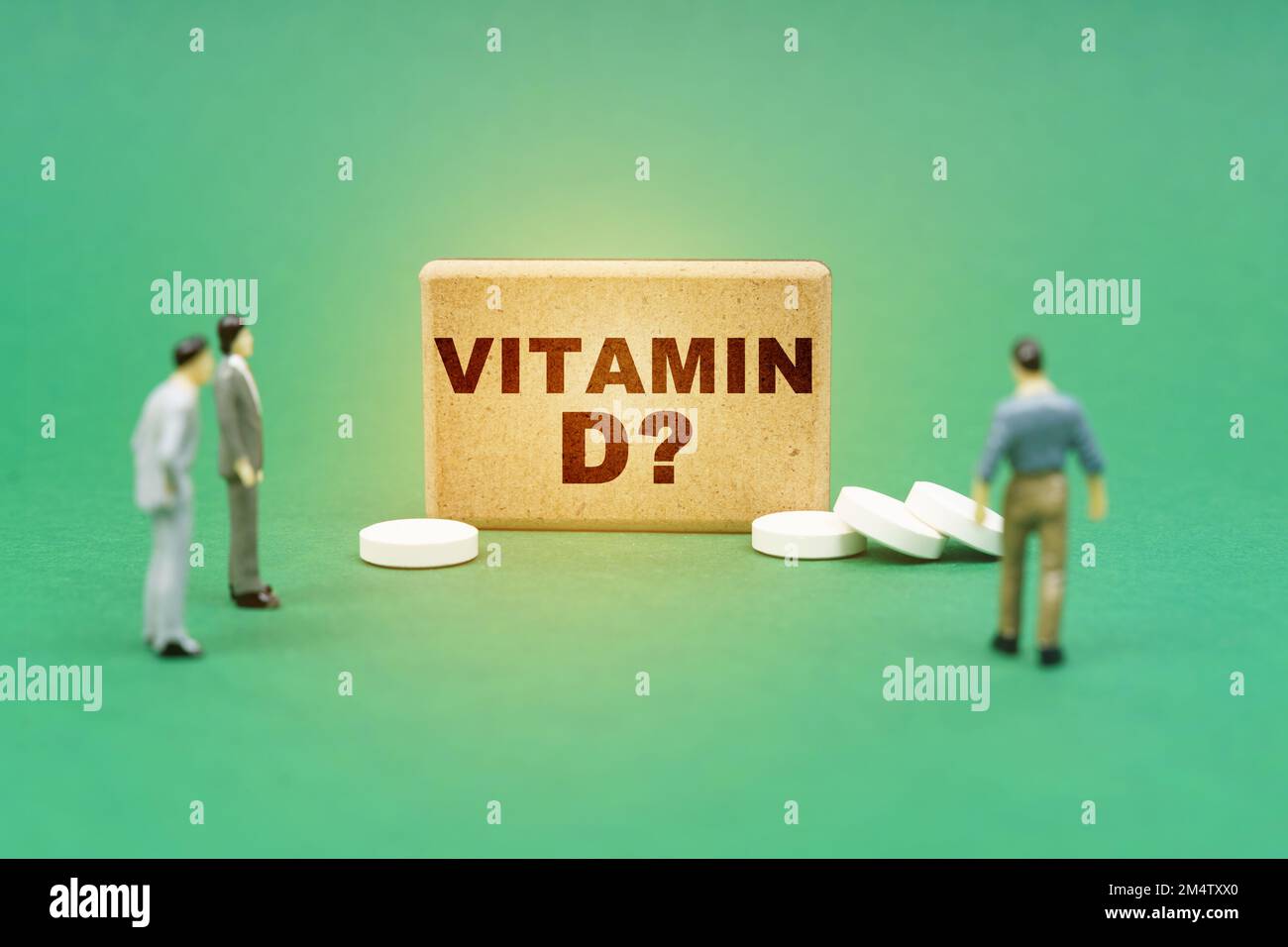 Medical concept. On the green surface are pills, miniature figures of ...