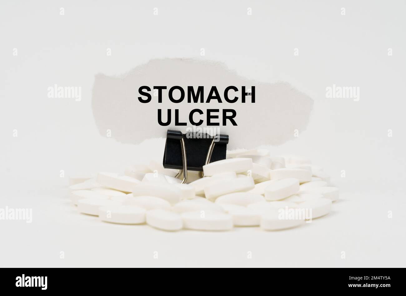 Medical concept. On a white surface are pills and torn paper with the ...