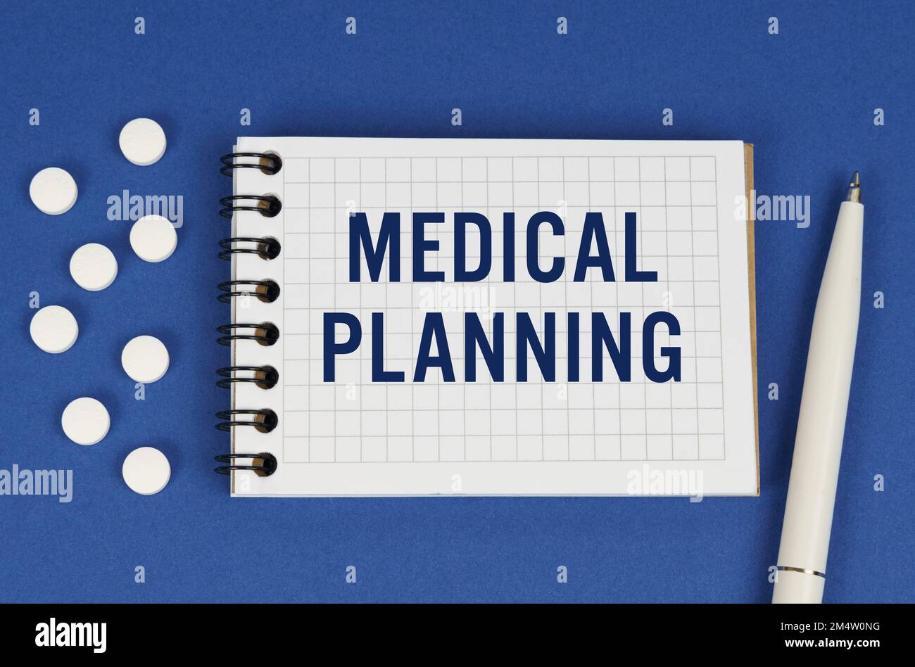Medical concept. On a blue background, a pen, tablets and a notepad ...