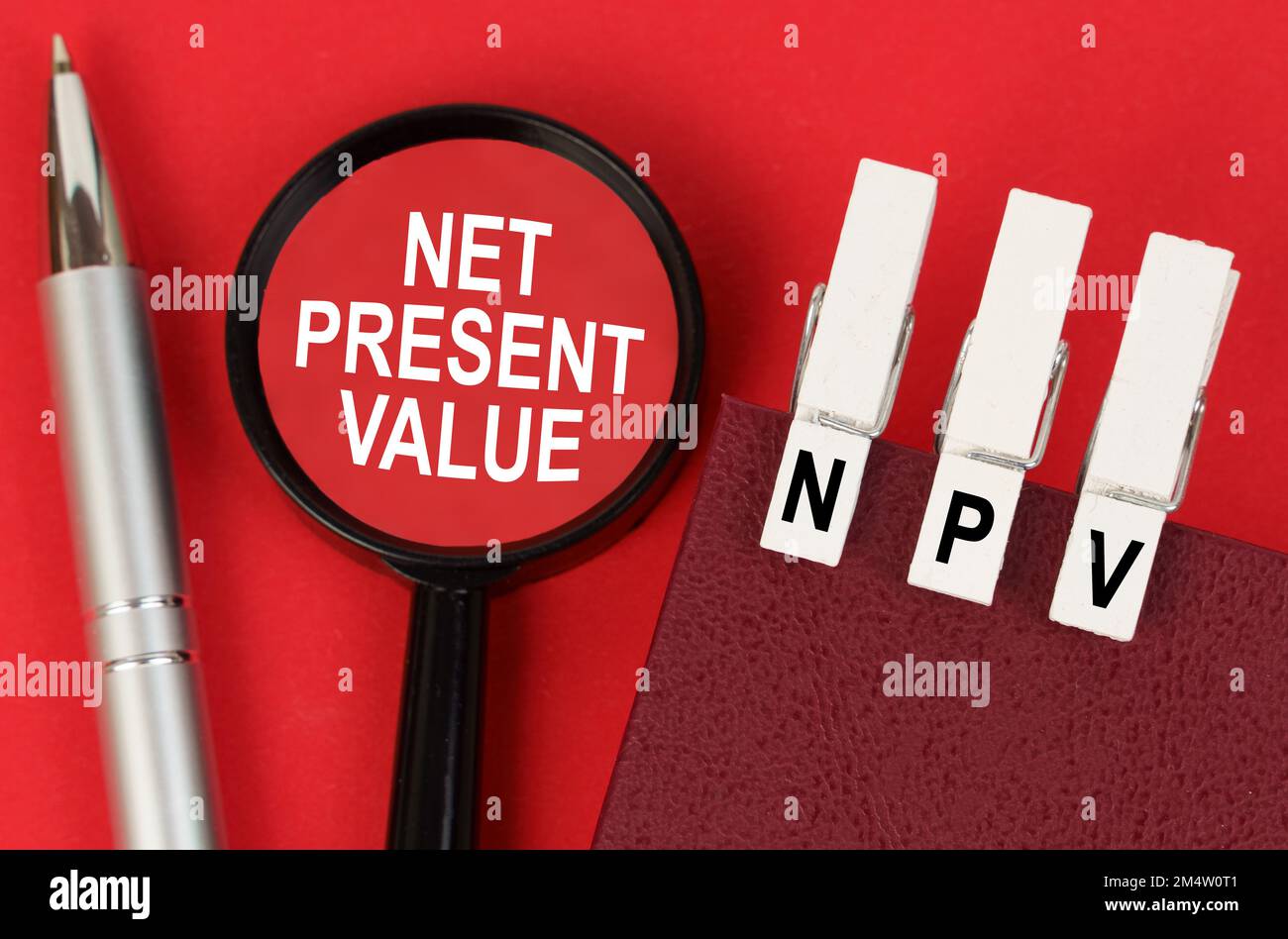 Business concept. On the red surface lies a pen, a notebook with ...