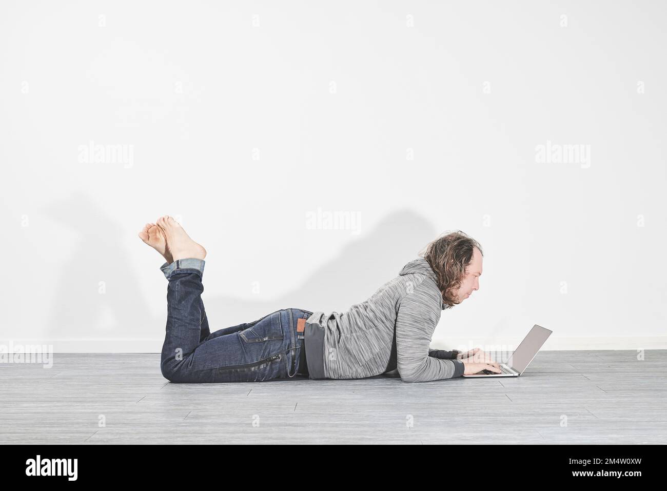 Man working with computer barefoot Stock Photo - Alamy