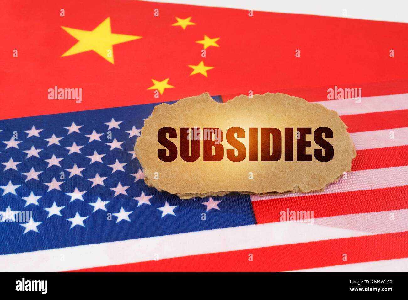 Political concept. On the flags of the USA and China lies a cardboard ...