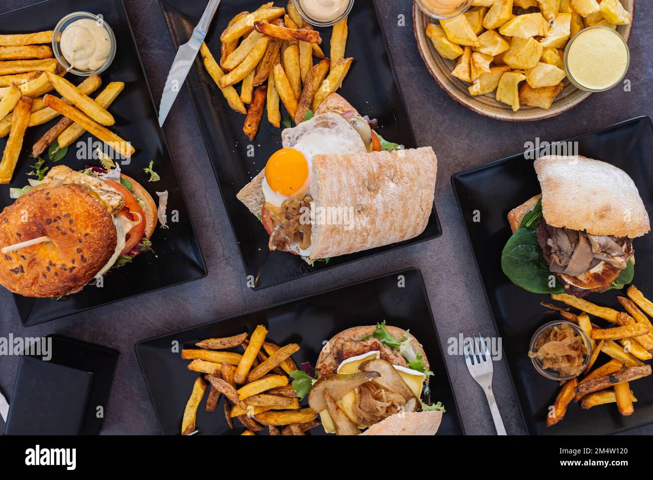 Fast food dinner on the barbecue table with hamburgers and french fries ...