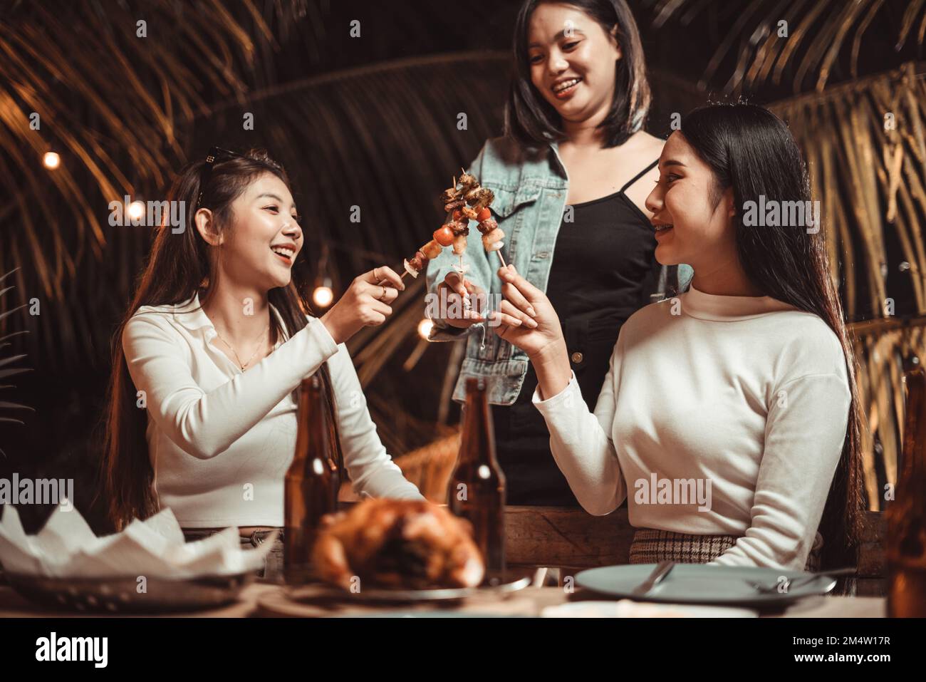 Group of women friends barbecue party eating grilled chicken and ...