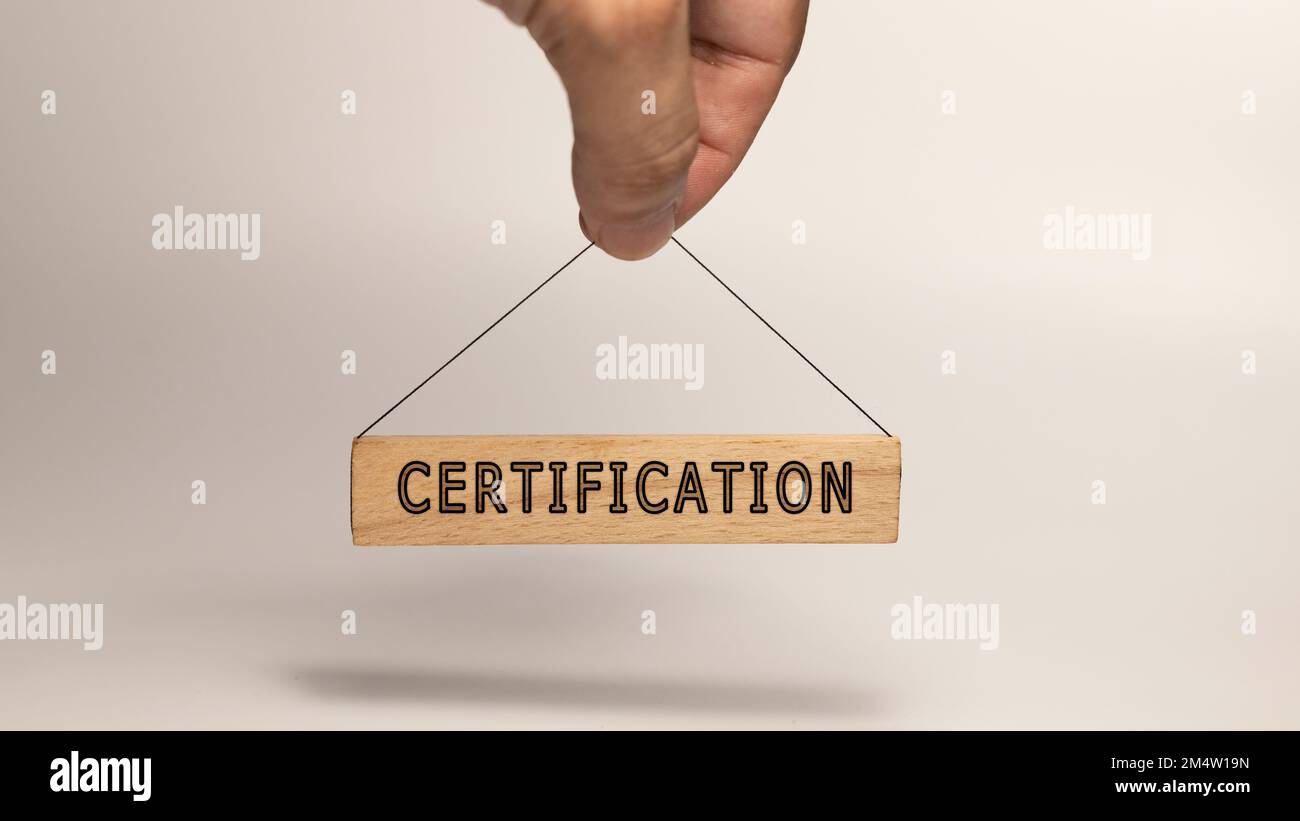 Certification word. Written on wooden sign hanging in human hand Stock ...