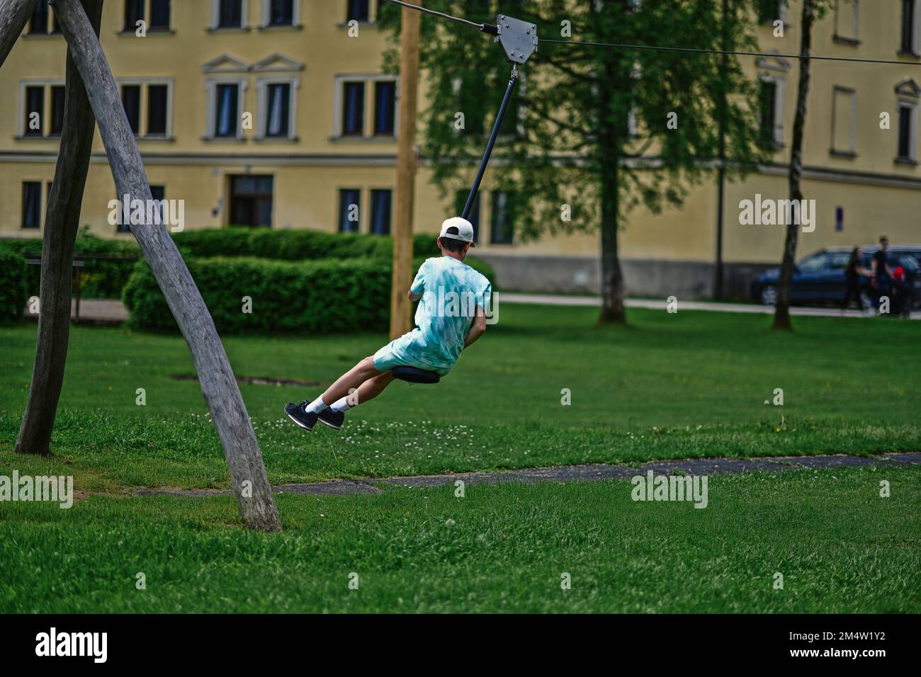 Boy swinging on rope at playground Stock Photo - Alamy