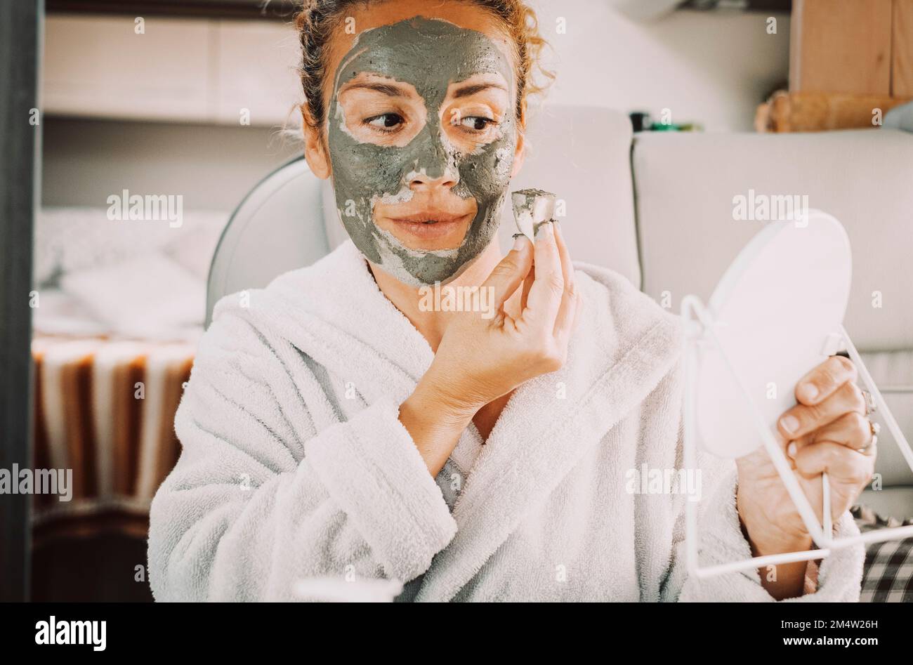 Portrait front view of young woman with skin cream treatment on face ...