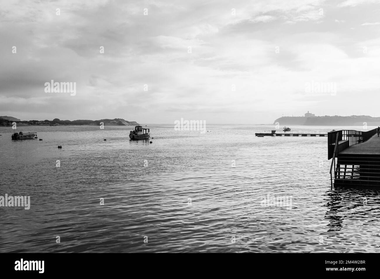 A grayscale shot of the sea with boats Stock Photo - Alamy