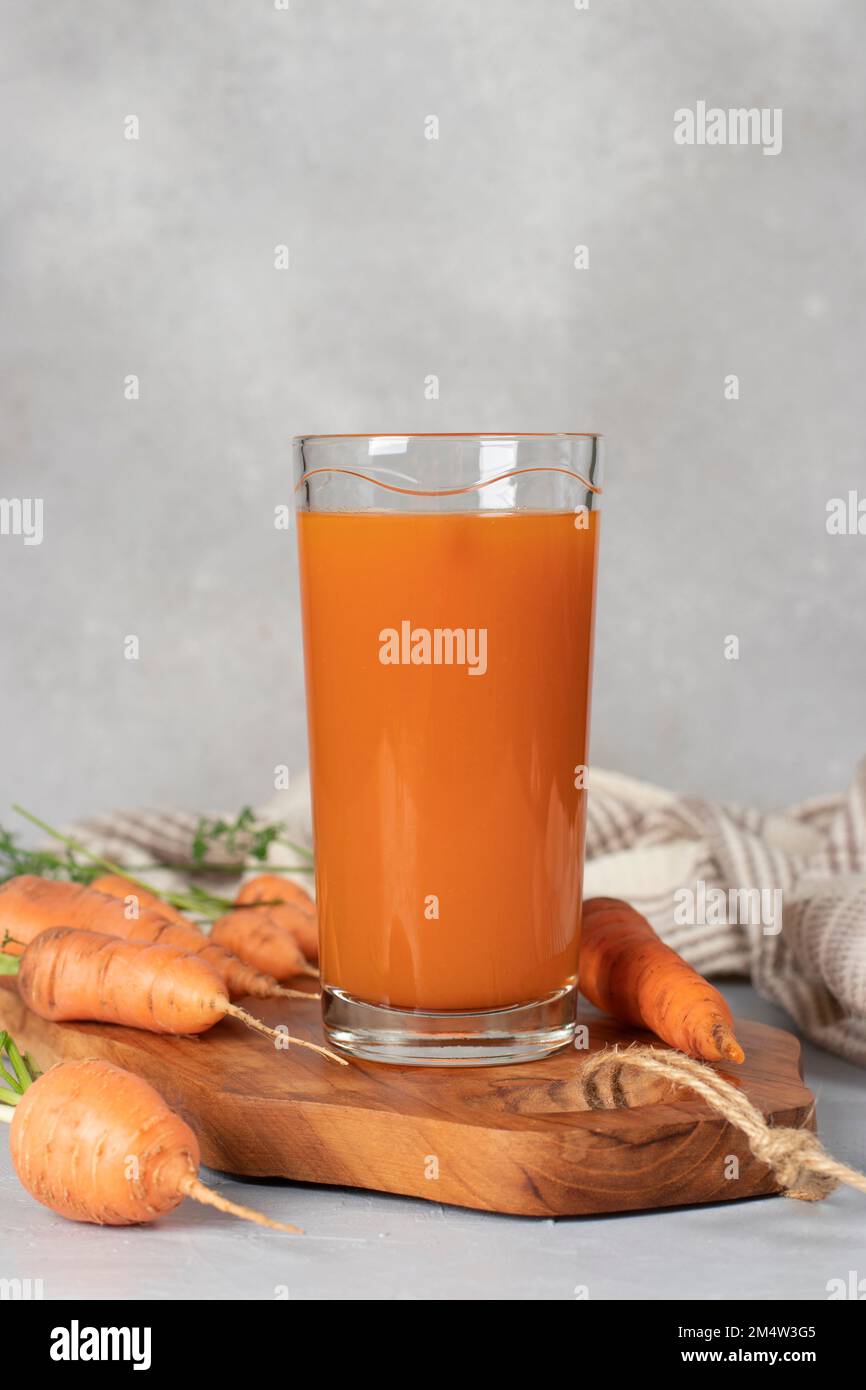 Fresh carrot juice in tall glass on gray background. Concept of healthy ...