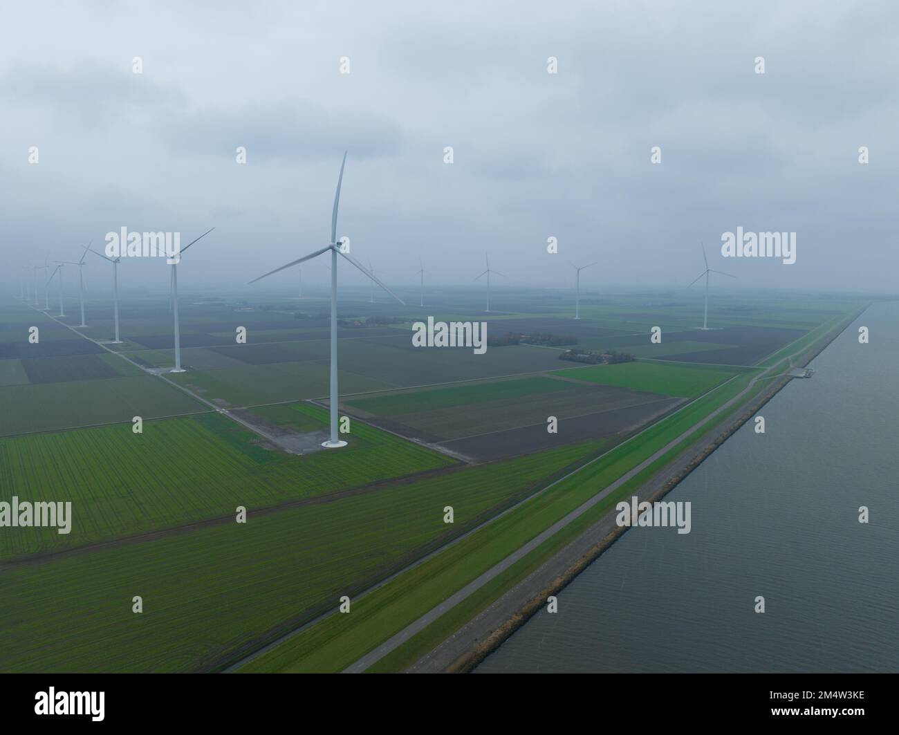 Wind turbine along a dyke. WInd energy power electricity sustainable ...