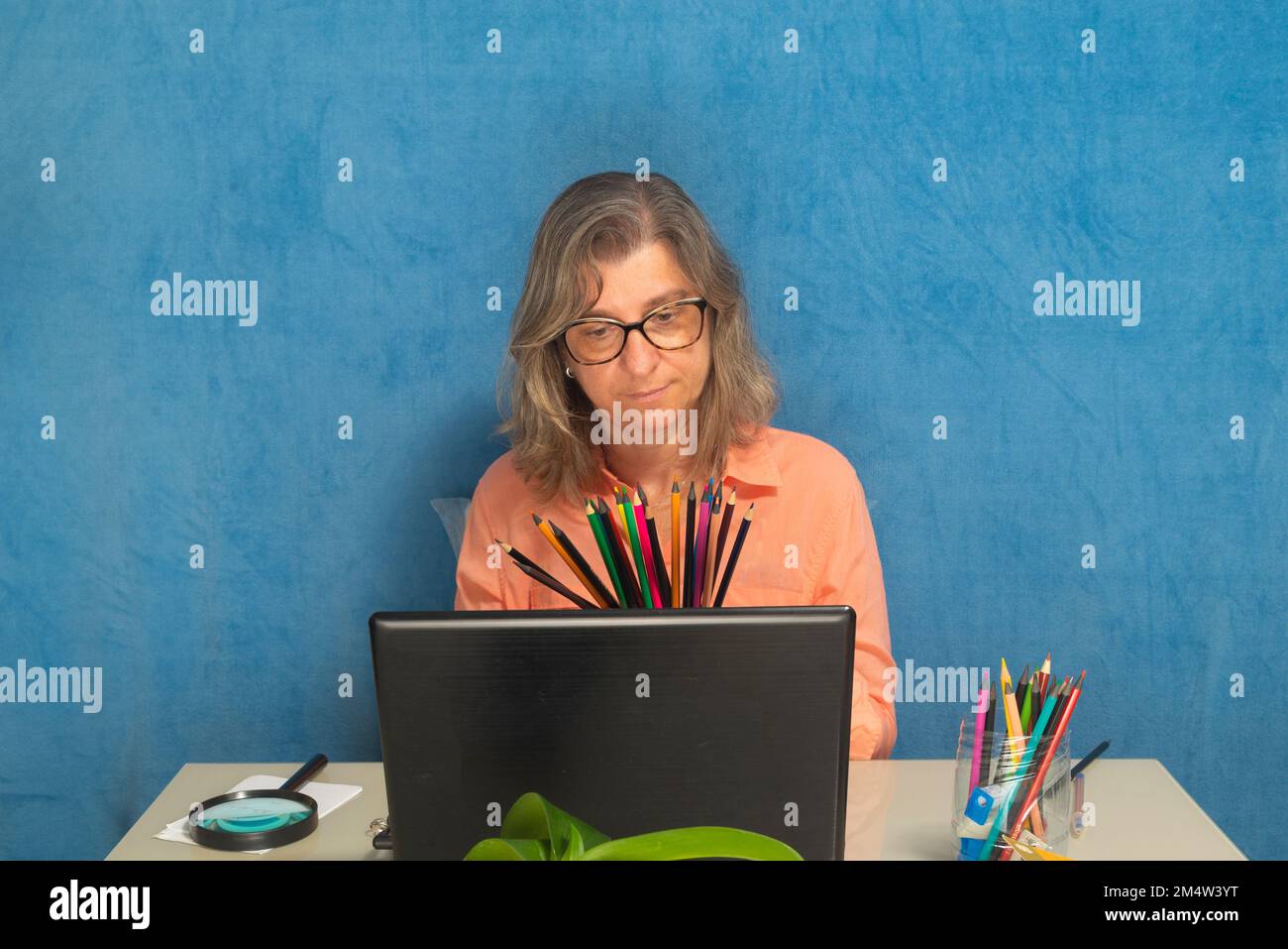 A female concentrated with laptop computer working from home or office ...