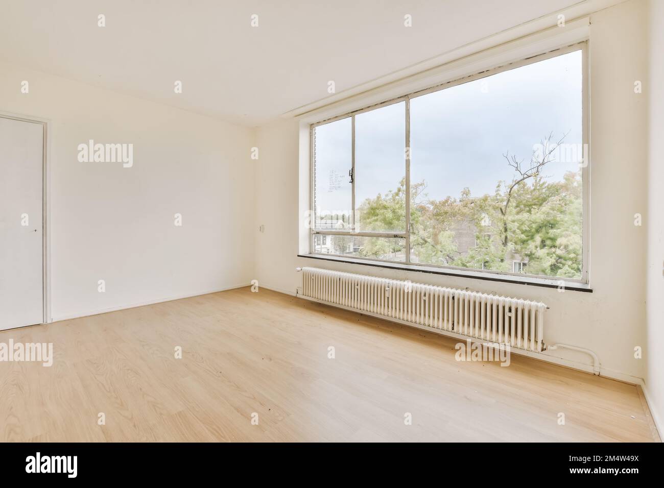 an empty room with wood floor and large window looking out onto the ...
