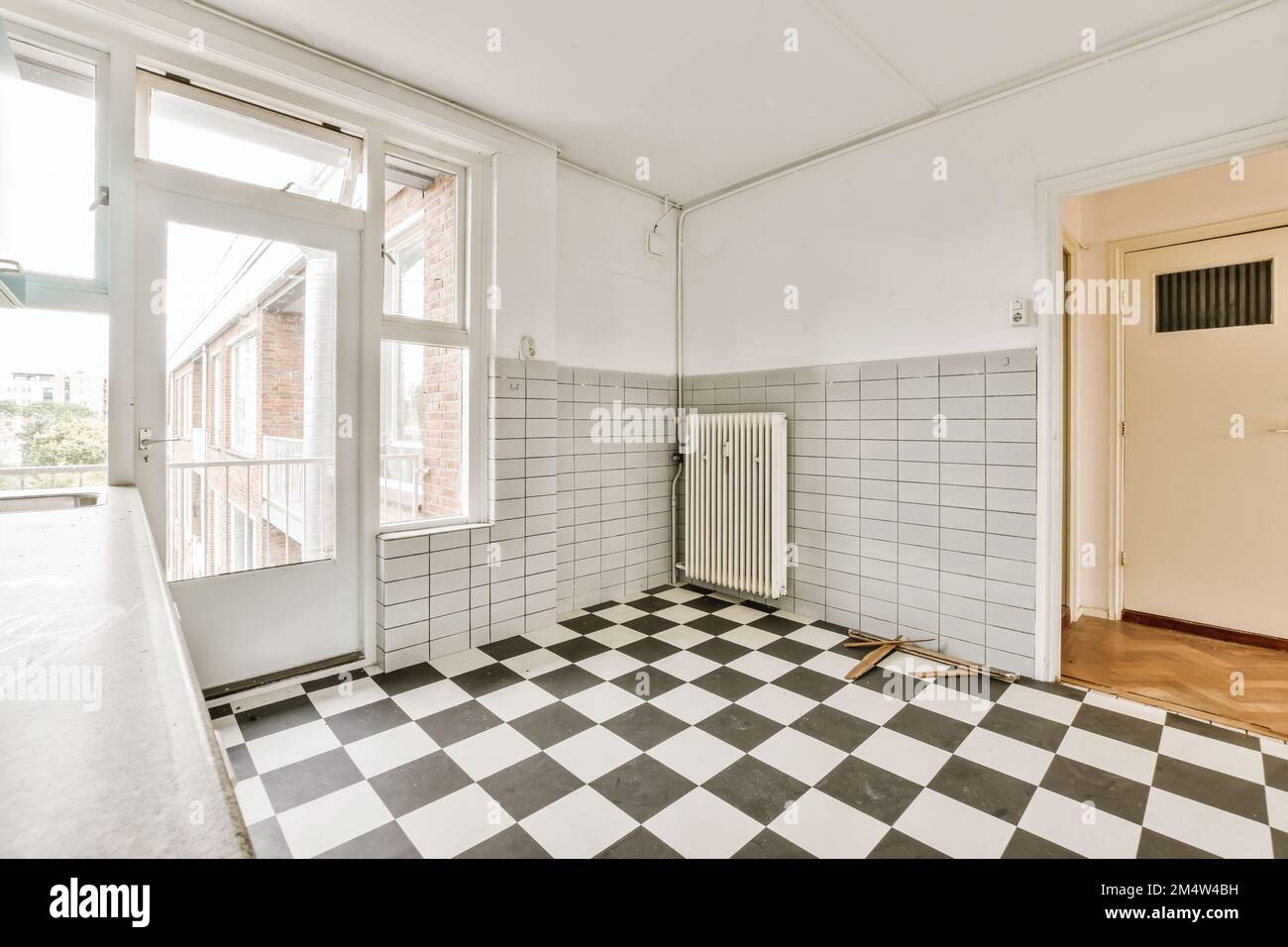 an empty room with black and white checkered tiles on the floor, in ...
