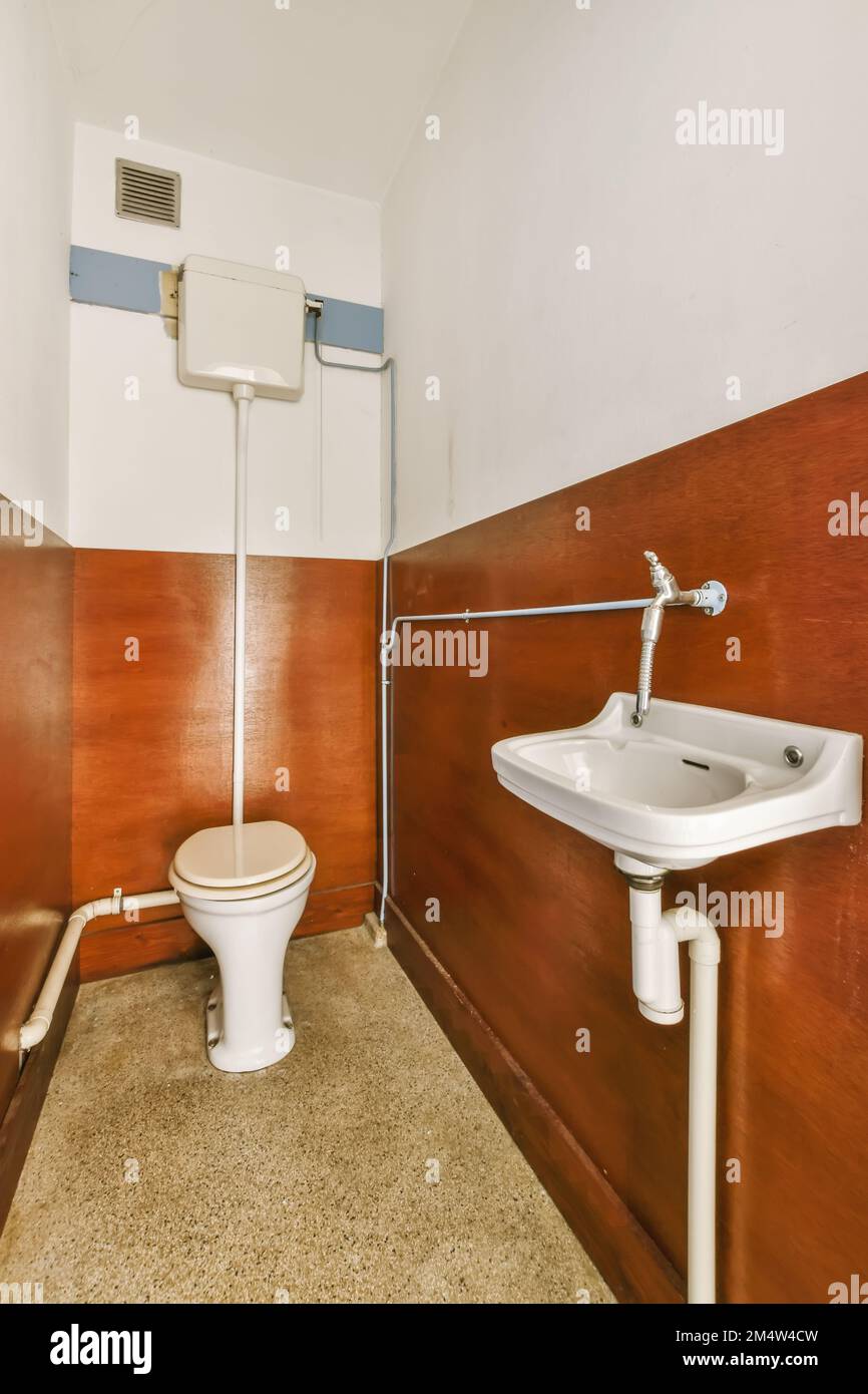 a toilet and sink in a small bathroom with wood paneling on the walls ...
