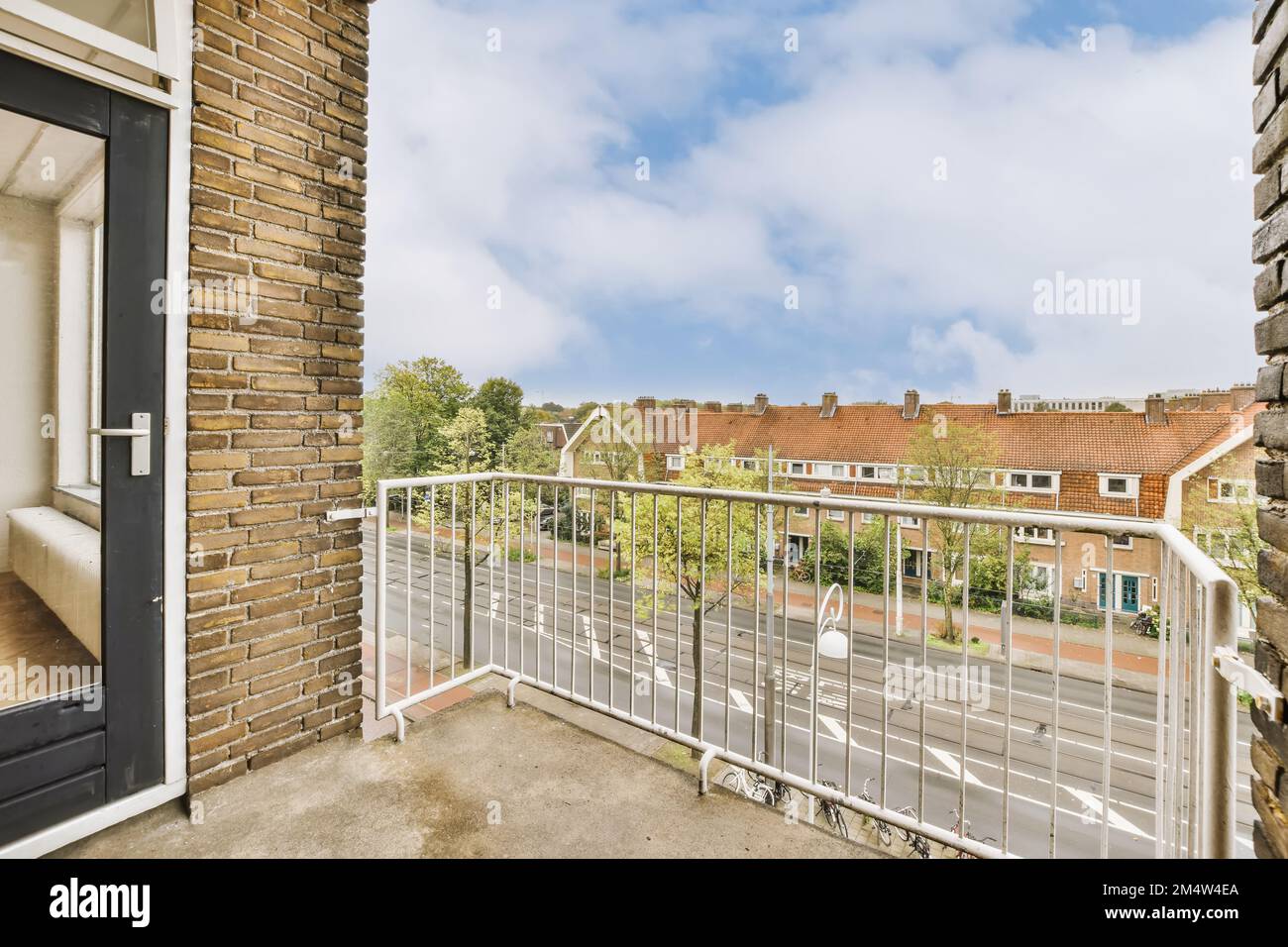 a balcony with a view of the street and houses in the distance, taken ...