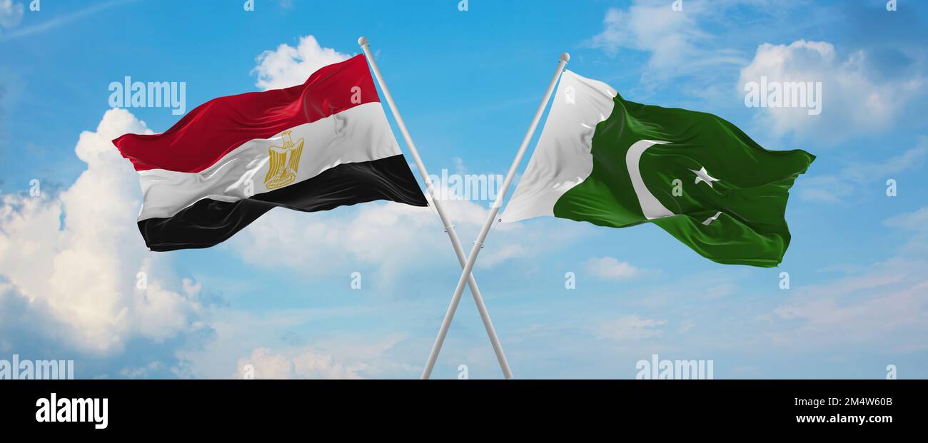 two crossed flags Pakistan and Egypt waving in wind at cloudy sky ...
