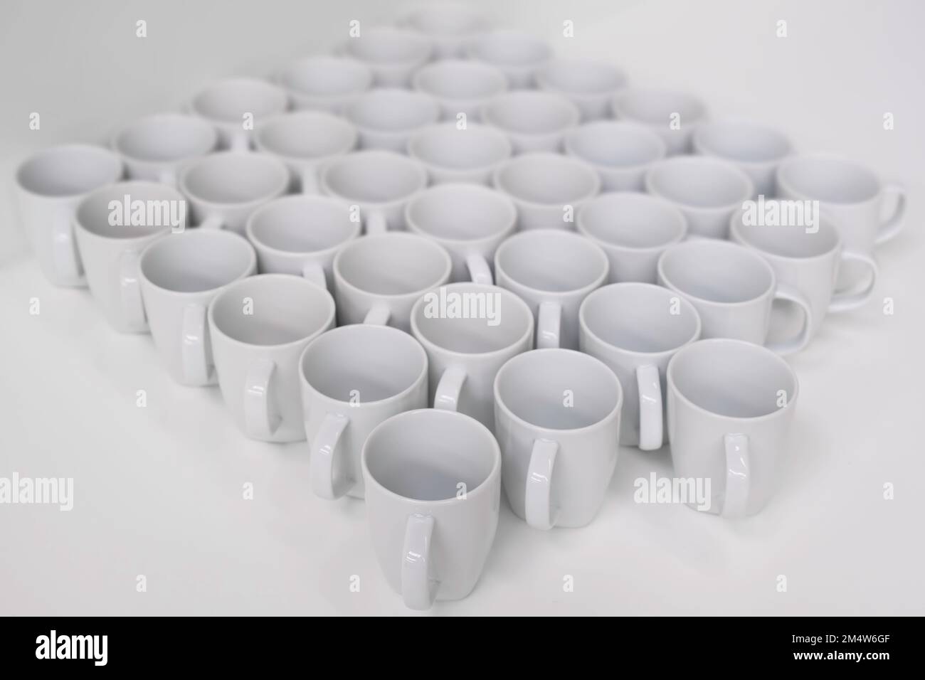 Diamond-shaped rows of white empty coffee cups on white background ...