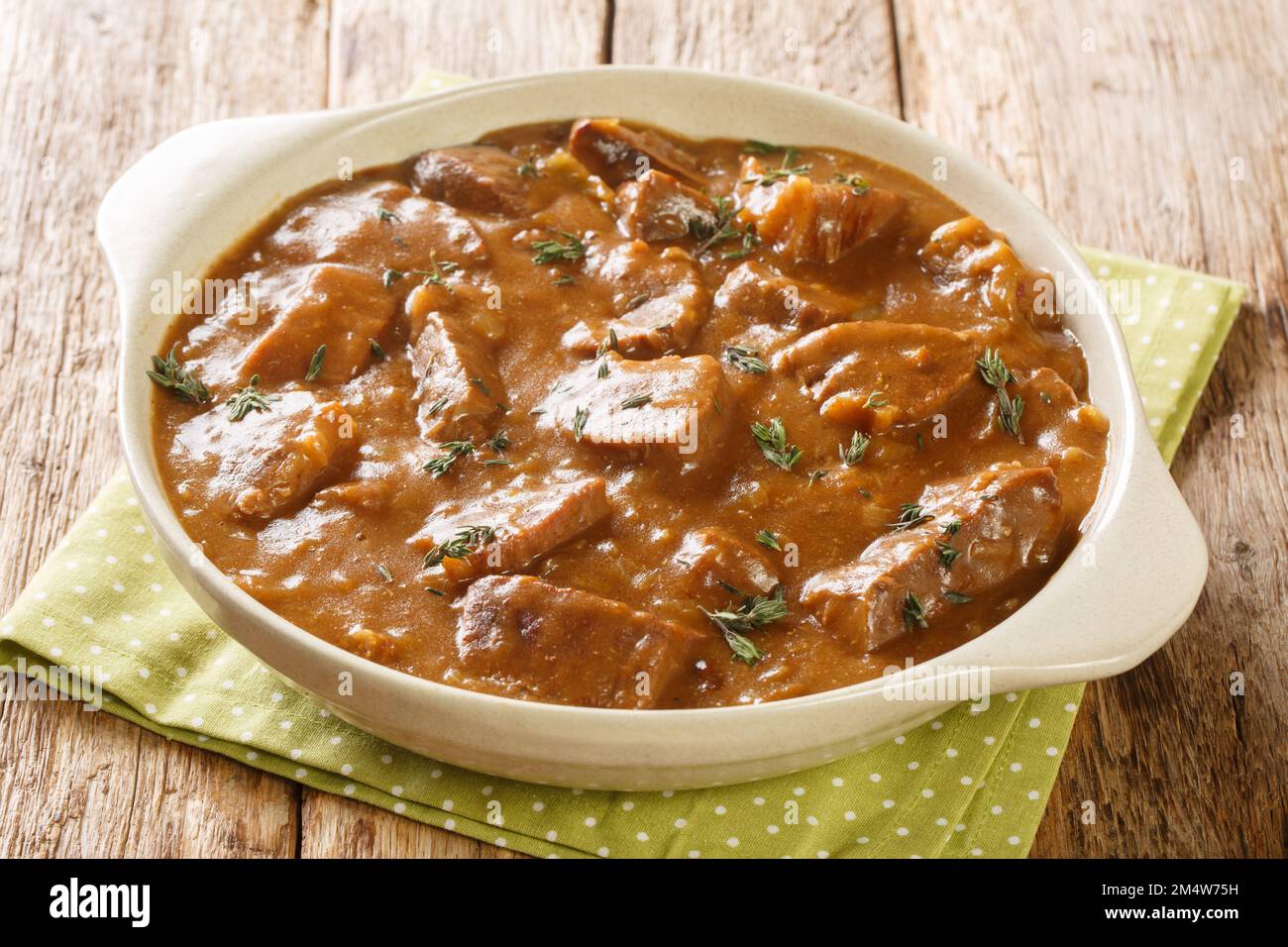 Belgian Carbonnade Beef and Beer Stew closeup in the pot on the wooden ...