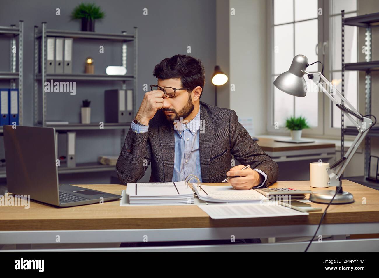 Overworked businessman taking off glasses feeling eyestrain sitting at ...