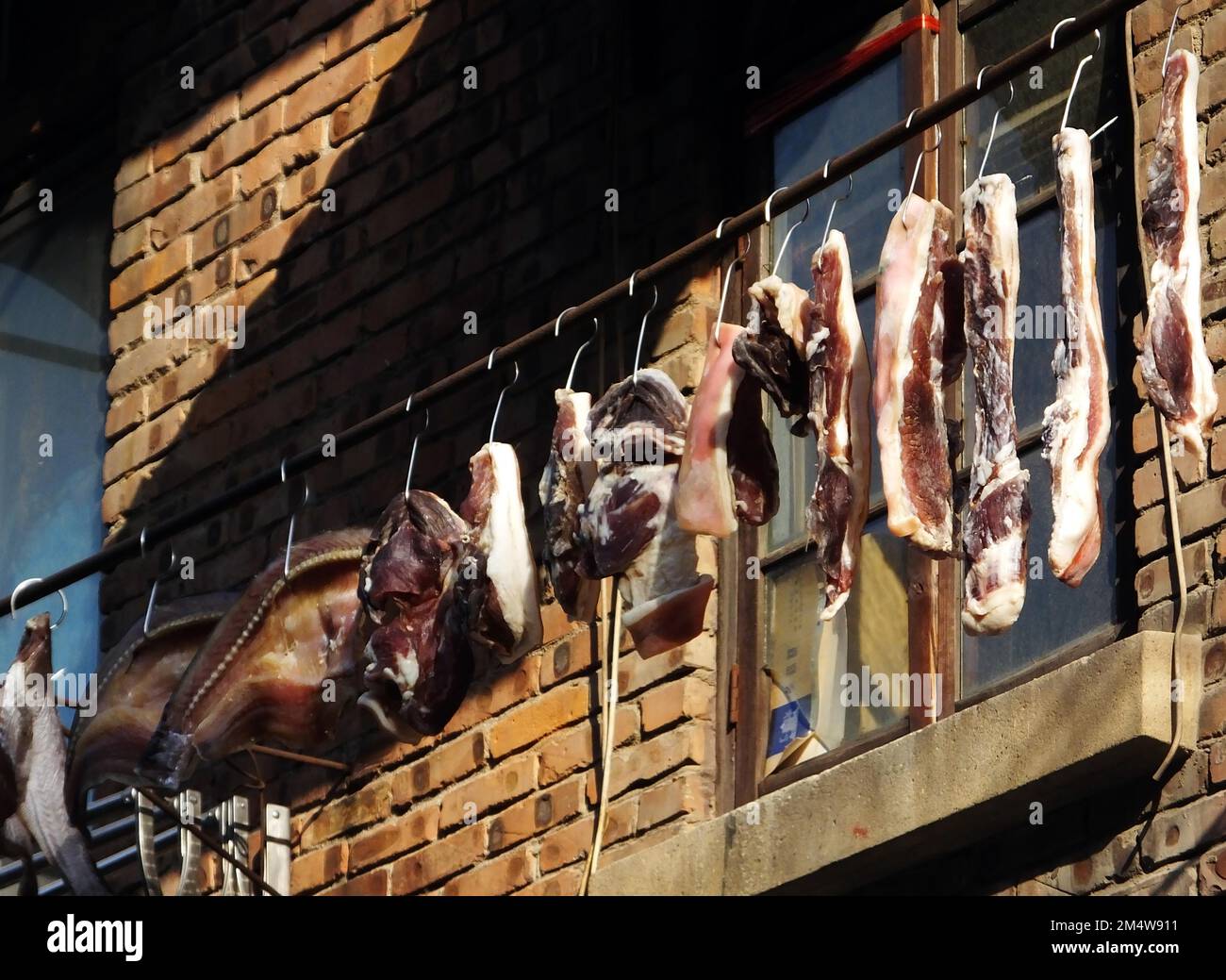 Residents hang and dry cured meat and fish for the spring festival in Yichang City, central ...