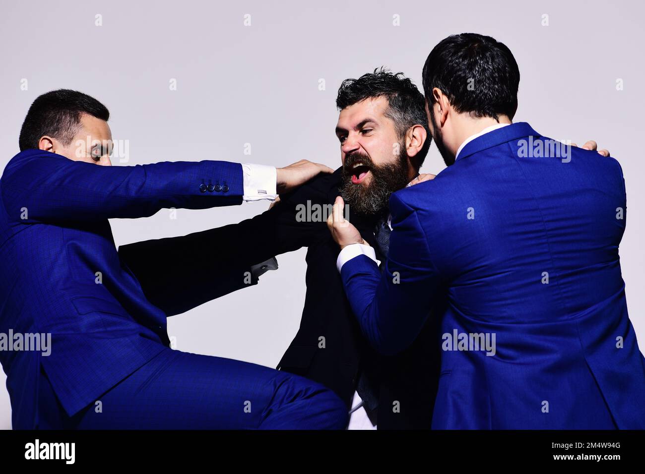 Businessmen with mad faces in formal suits on grey background Stock ...