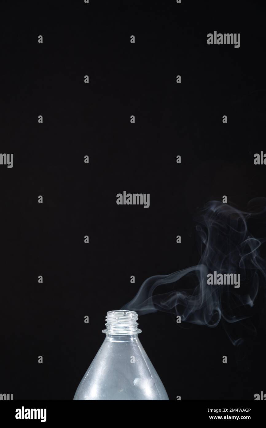 The smoke coming out of a plastic bottle on black background ...