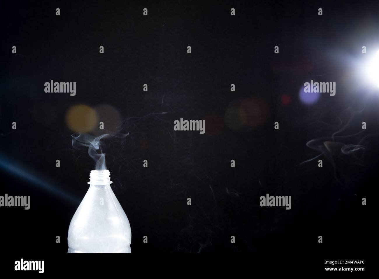 The smoke coming out of a plastic bottle on black background ...