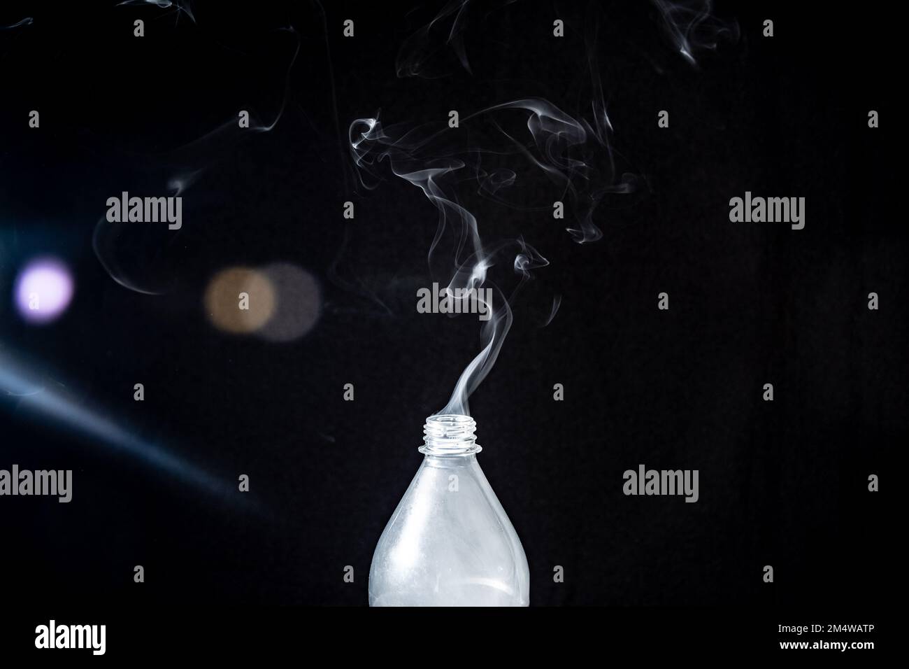 The smoke coming out of a plastic bottle on black background ...