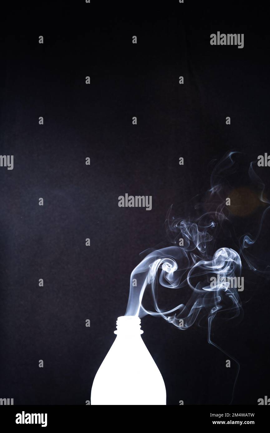 The smoke coming out of a plastic bottle on black background ...