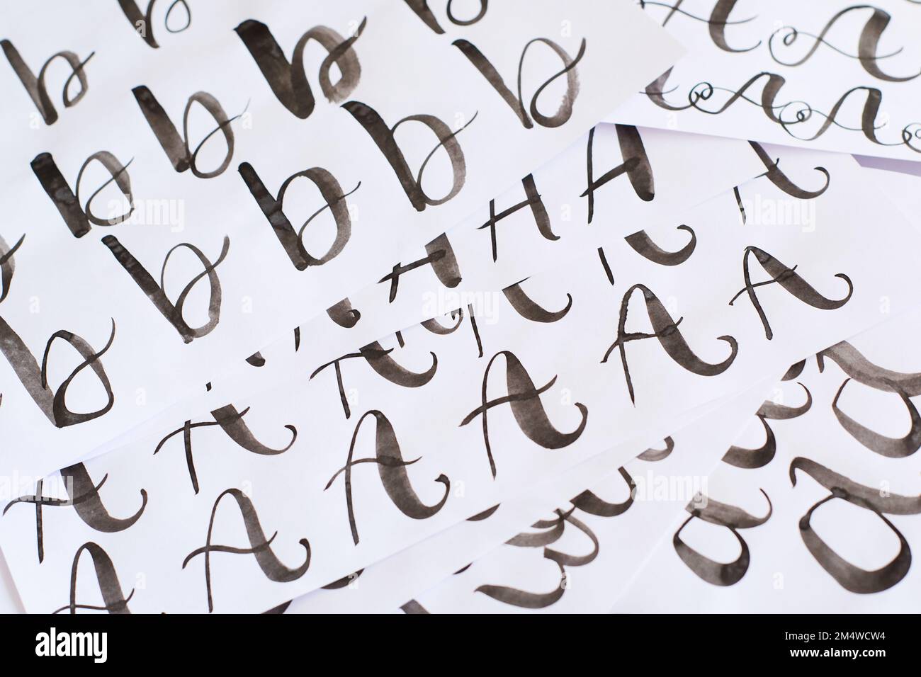 Several white sheets with calligraphic exercises. Calligraphy practice ...