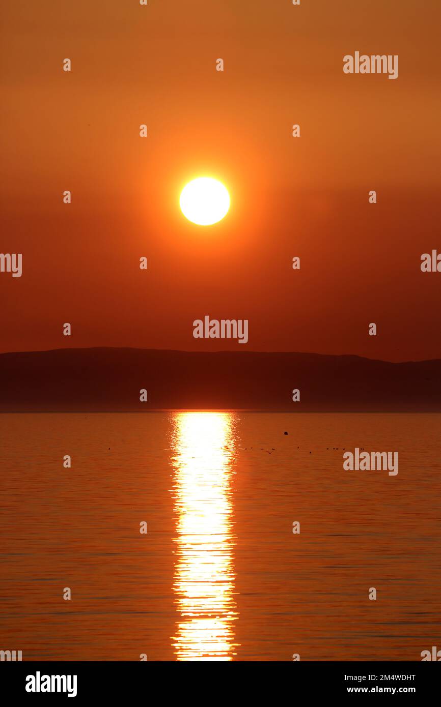 The Isle of Arran, Scotland, UK.Sunset over the island from the beach ...