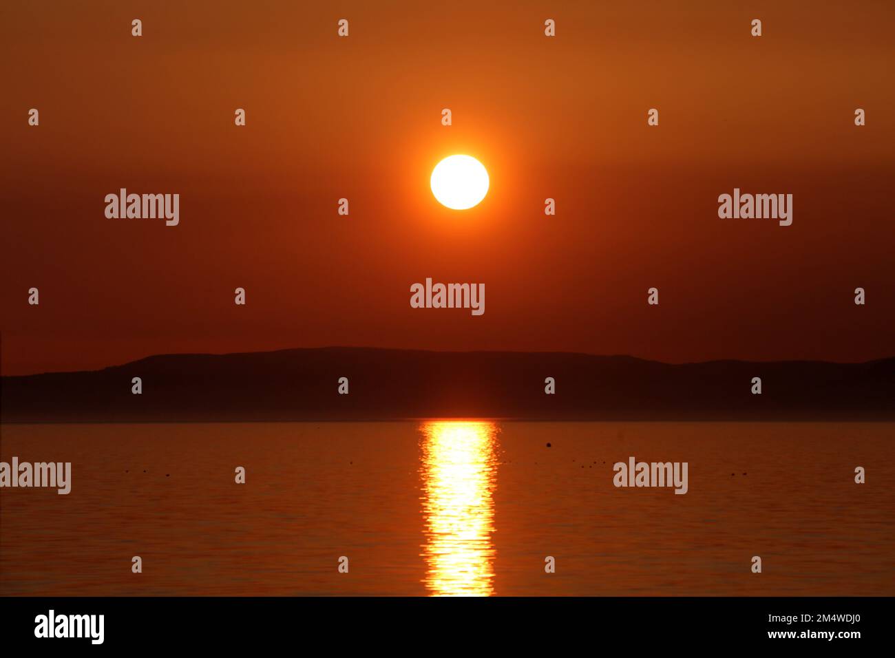 The Isle of Arran, Scotland, UK.Sunset over the island from the beach ...