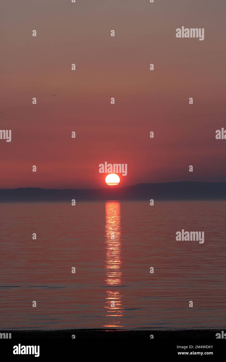 The Isle of Arran, Scotland, UK.Sunset over the island from the beach ...